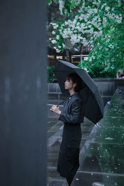 우산을 들고 빗속에 서 있는 여자 사진 Unsplash의 무료 비 이미지