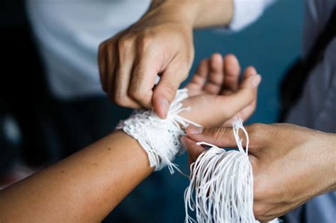 Premium Photo Person Tying Strings On Friends Hand