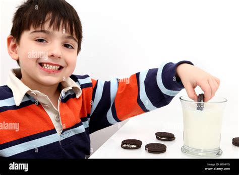Adorable Five Year Old Boy Dunking Cookies In Milk Stock Photo Alamy