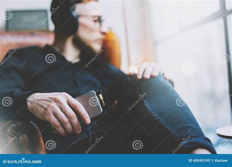 听音乐现代顶楼演播室的照片英俊的有胡子的人耳机 供以人员坐在看窗口的葡萄酒椅子，举行sm 库存图片 图片 包括有 蓝色 证实 69045195