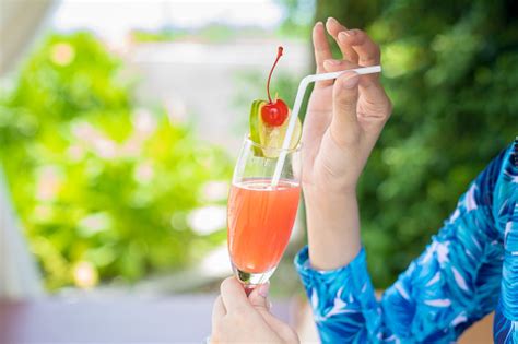 아시아 여자 휴식 에 The 해변에서 그녀의 빨간 라임 체리 칵테일 에 그 손 에 오프닝 여름 날 건강관리와 의술에 대한 스톡