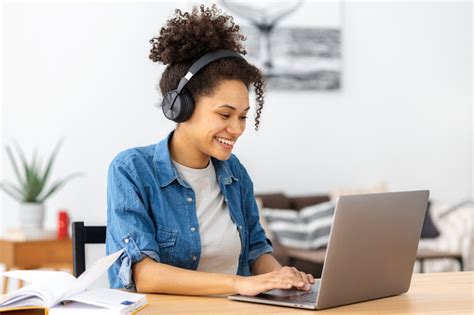 웃는 여자 학생 온라인 학습 집에서 학습 노트북 컴퓨터와 원격 교육을위한 화상 통화를 사용하는 아름다운 아프리카 계 미국인 여학생 공부 교육 강좌에 대한 스톡 사진 및 기타