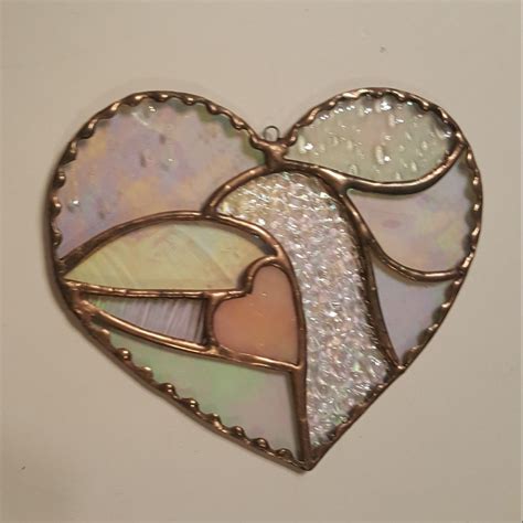 A Heart Shaped Stained Glass Ornament Hanging On A Wall