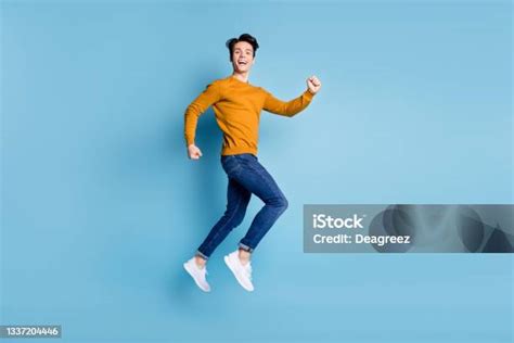 감동 브루넷 밀레니엄 남자 점프 착용 스웨터 청바지 블루 컬러 배경의 전신 프로필 사진 점프에 대한 스톡 사진 및 기타 이미지