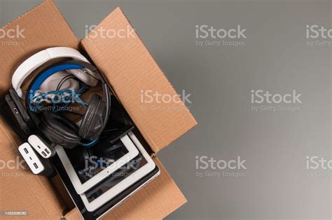 오래된 중고 컴퓨터 디지털 태블릿 스마트폰 회색 배경에 재활용을 위한 전자 기기로 가득 찬 골판지 상자 기부 전자 폐기물 재사용을위한 전자 폐기물 리퍼비시 재활용 개념 전자