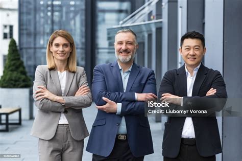 성공적인 드림 팀 미소 짓고 카메라를보고있는 아시아 남성과 비즈니스 여성의 다양한 비즈니스 그룹 사무실 건물 밖에서 교차 된 팔을 가진 동료 전문 투자자 및 은행가 기업