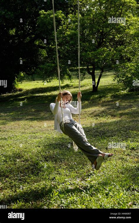 Woman Swinging In A Tree Swing Stock Photo Alamy