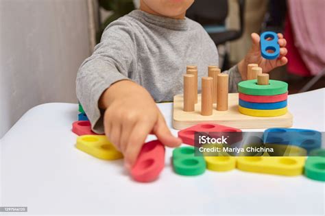 아이는 선별기를 수집합니다 아이들을위한 교육 논리 장난감 아이들의 손을 클로즈업 몬테소리 어린이 발달 게임 흰색 배경에 여러 가지 빛깔의 논리 선별기 교육에 대한 스톡 사진