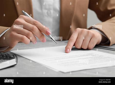 Woman Signing Document At Light Grey Marble Table Closeup Stock Photo Alamy