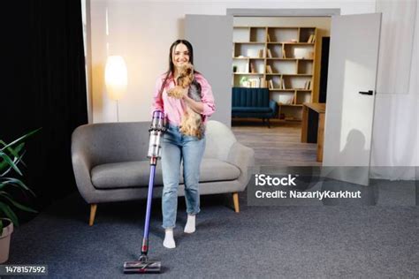진공 청소기와 개를 손에 들고 거실에서 진공 청소기로 청소하는 여자 가사 집안일에 대한 스톡 사진 및 기타 이미지 가사 집안일 가정 생활 가정의 방 Istock