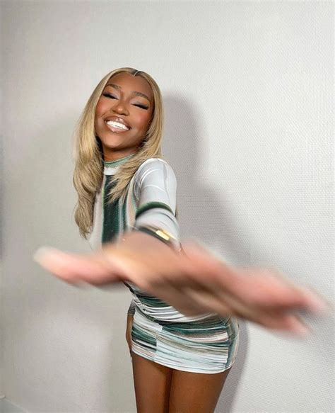 A Woman Is Smiling And Holding Out Her Hands In Front Of The Camera