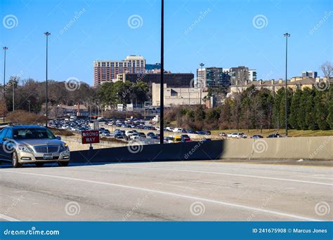 A Freeway With Cars Driving In Bumper To Bumper Traffic With Tall Black