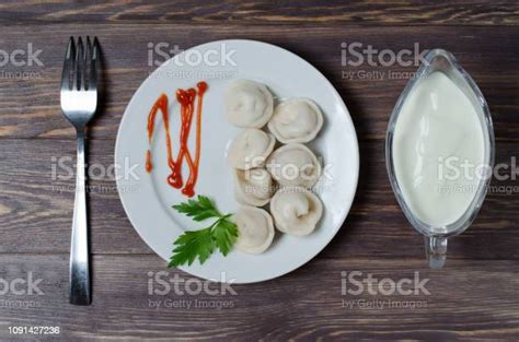 전통적인 러시아만 두 라비 올 리 빨간 소스와 파 슬 리와 흰 접시에 Pelmeni 어두운 나무 배경입니다 검은색에 대한 스톡