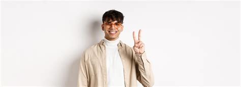 Premium Photo Handsome Caucasian Guy In Glasses Showing Two Fingers