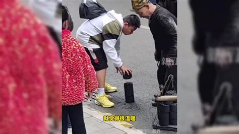 老爷爷用扁担挑煤球，不小心掉在地上， 小男孩帮忙捡起来