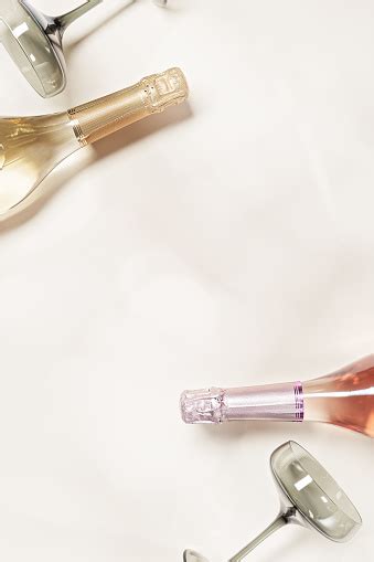 화이트 와인과 로제 와인이 든 샴페인 또는 스파클링 와인 병 와인 잔 회색 유리 로맨스 축제 음료 개념 햇빛의 눈부심 세련된 색상의 샴페인 잔 미의 건강관리와 의술에 대한