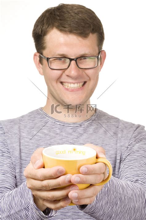 拿着黄色杯子的男人（专注于杯子）高清摄影大图 千库网