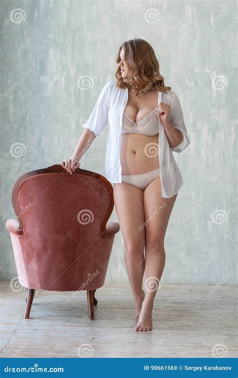 La Bella Ragazza Paffuta In Biancheria Intima Sta Tenendo La Mano Su Un