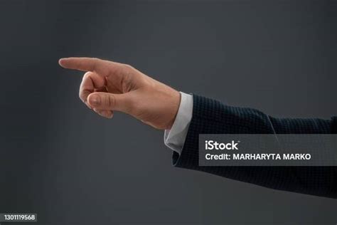 양복을 입은 남성 핸드는 회색 배경에 검지 손가락 제스처를 보여줍니다 네비게이터 개념 머리 클로즈업 30 34세에 대한 스톡