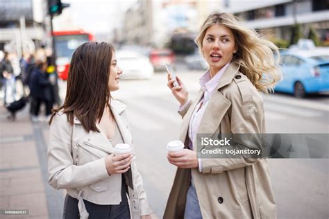 도시에서 버스를 기다리는 동안 테이크 아웃 커피를 마시는 젊은 여자 친구들 2명에 대한 스톡 사진 및 기타 이미지 2명 Z세대 거리 Istock
