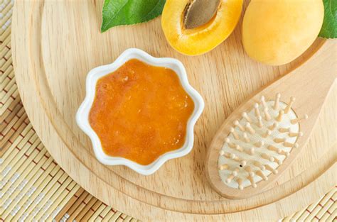 작은 흰색 그릇과 나무 헤어 브러시에 집에서 만든 살구 얼굴이나 헤어 마스크 자연의 아름다움 트리트먼트 와 스파 조리법 상단