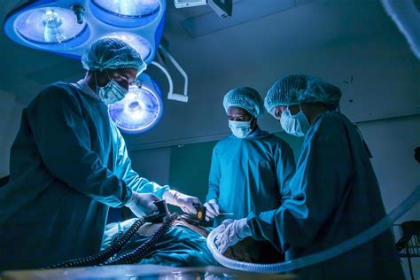 Team Of Surgeon Doctor Using Defibrillator To Give Electrical Shock To