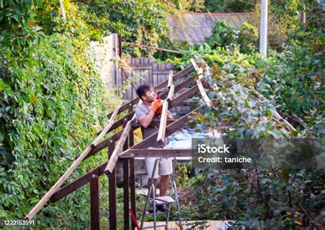 Pria Membangun Atap Kayu Di Luar Ruangan Berdiri Di Tangga Foto Stok