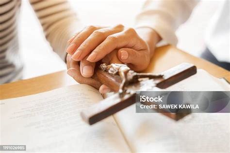 基督教婦女用雙手在神聖的聖經和木十字架上祈禱女人祈求上帝祝福希望過上更好的生活並相信善良 照片檔及更多 一起 照片 一起 人 人手