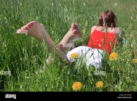 Young Barefoot Woman Lying On Her Stomach In A Flowering Spring Stock
