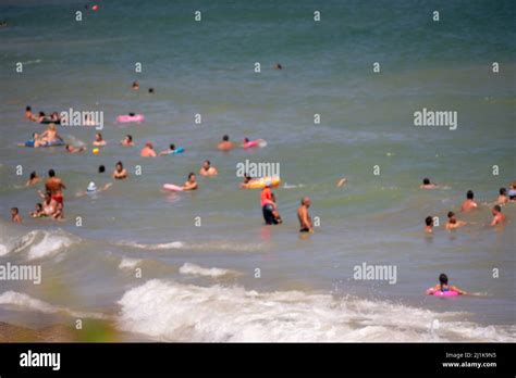 People On The Beach Having Fun In The Water Blurred Background Stock