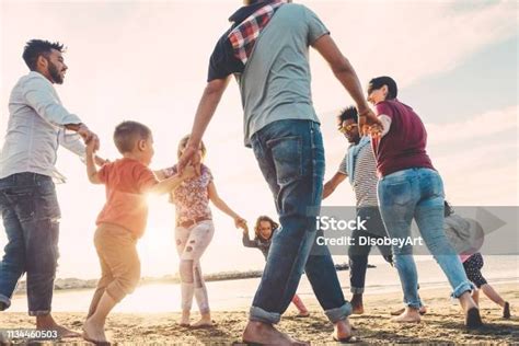가족 친구 들이 석양 해변에서 즐거운 시간을 보내세요아버지 어머니 어린이와 삼촌이 함께 연주사랑 관계 파티 및 축 하 개념