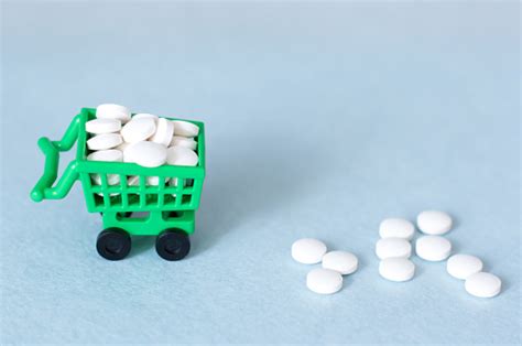 파란 배경에 흩어져 흰색 알약 옆에 약물녹색 쇼핑 카트 고립 의료 개념 치료 0명에 대한 스톡 사진 및 기타 이미지 0명 건강관리와 의술 구매 Istock