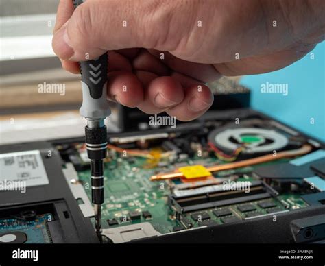 The Master Repairs A Broken Laptop With A Screwdriver Specialist And Old Broken Laptop Stock