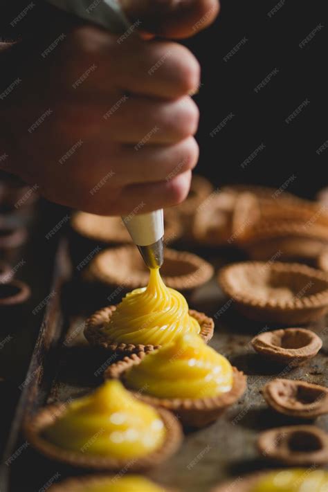 Premium Photo Close Up Of Baker Piping Mixture Into Pastries