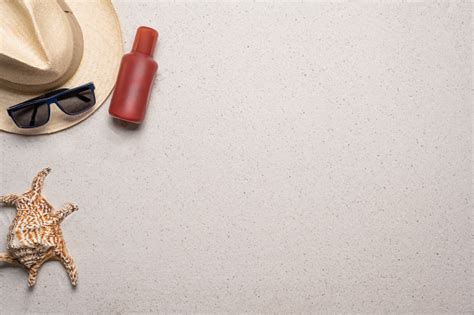 여름 해변 휴가 컨셉으로 자유로운 텍스트 공간을 즐길 수 있다 평면도 남자 밀짚모자 선글라스 선탠 오일이 있는 평면 레이아웃과 고운 모래 배경에 큰 조개껍데기 관광에 대한