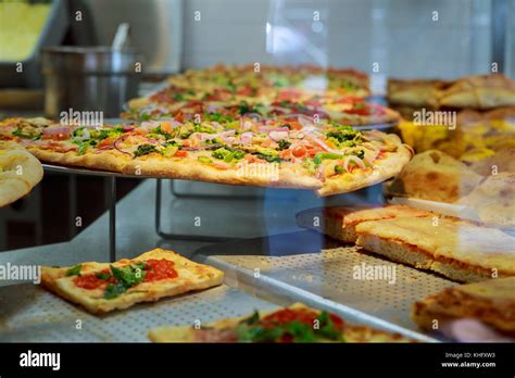 Fresh Italian pizza in New York City pizzeria window Slice of hot pizza cheese lunch or dinner ...