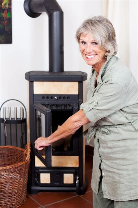 Senior Lady Puting Wood In The Stove Stock Image Image Of Heating