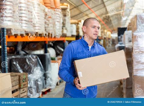 Positive Warehouse Worker Dragging Boxes On Hands Stock Photo Image