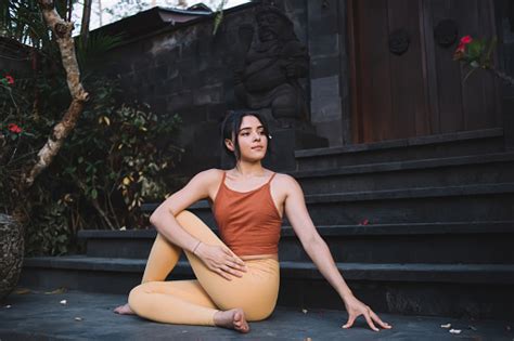 요가에 앉아 활동복을 입은 예쁜 백인 여성은 호흡과 레크리에이션에 만족하고 아사나에 앉아 있는 20대 소녀는 요가 연습 중 조화에 도달하는 평온함과 웰빙을 느낍니다 20