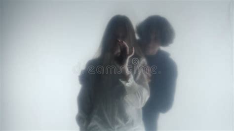Silhouette Of A Man And A Woman Behind A Frosted Curtain Or Glass Close