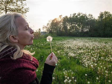 Premium Photo Young Woman Blowing Dandelion