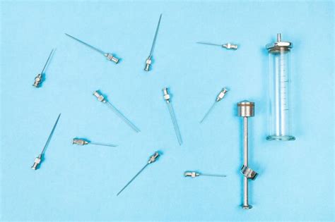 Premium Photo Steel Hypodermic Needles And Glass Syringe On Blue