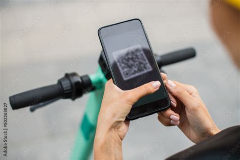 Woman Scan QR Code By Smart Phone To Unlock And Rent Electric Push Scooter On Street Eco