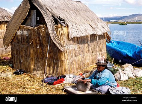 Uros Woman Grinding Corn On Floating Islands In Lake Titicaca Peru