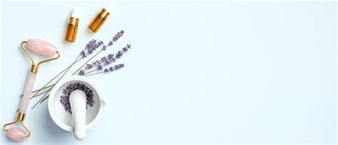 라벤더 꽃 에센셜 오일 파란색 배경에 얼굴 마사지 도구와 박격포 플랫 레이 상단 보기 복사 공간 천연 유기농 Spa 화장품