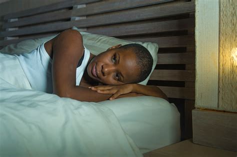 젊은 슬 프 고 우울 검은 아프리카 미국 여자의 잠 못 드는 침대에 극적인 라이프 스타일 초상화 고통 두통 불면증 수 면 장애 및 불안 문제 느낌 불쾌 하 고 화가 걱정