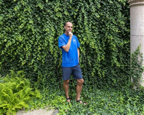 47 Year Old Caucasian Male Posing In Front Of A Dense Wall Of Green Ivy