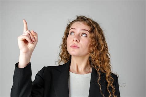 Premium Photo Young Woman In Black Jacket Pointing Up