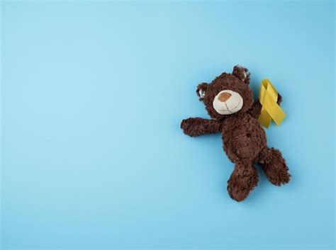 Premium Photo Little Brown Teddy Bear Holds In His Paw A Yellow