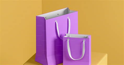 노란색 큐브 연단에 있는 두 개의 보라색 종이 봉지 밝은 배경 매장에서 판매 및 구매의 개념입니다 쇼핑백 및 온라인 주문